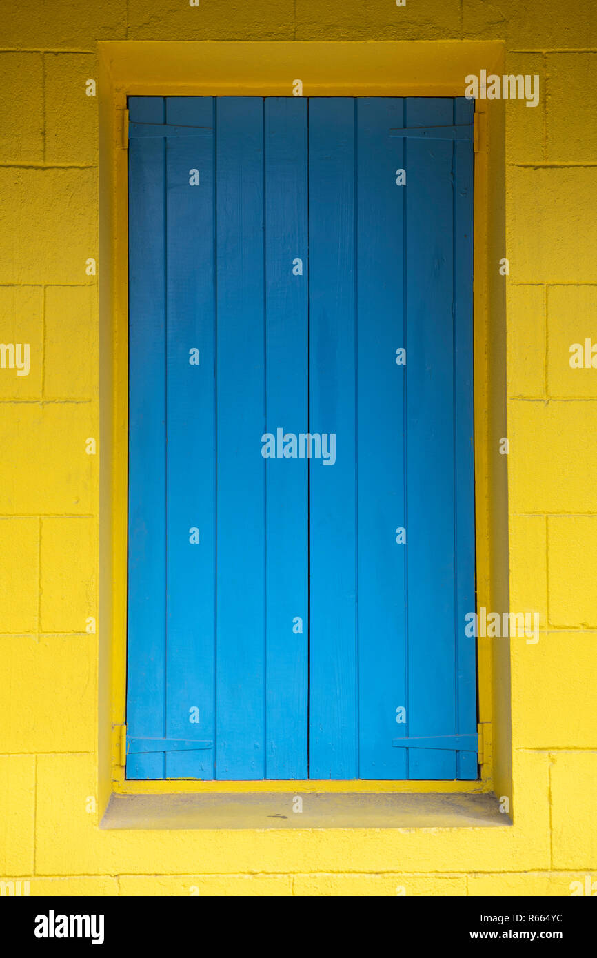 Bright blue window against bright yellow brick wall, Antigua Stock ...