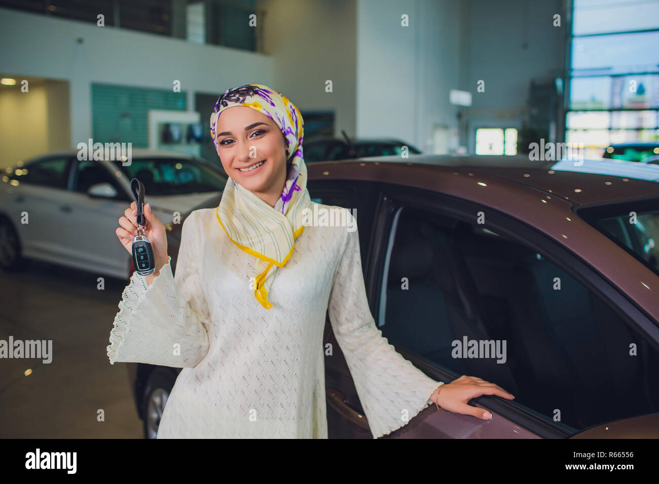 property and people concept - muslim woman in hijab with car key over ...