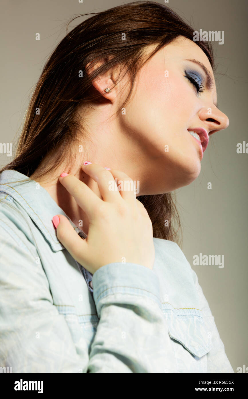 Health problem. Young woman scratching her itchy nack with allergy rash ...