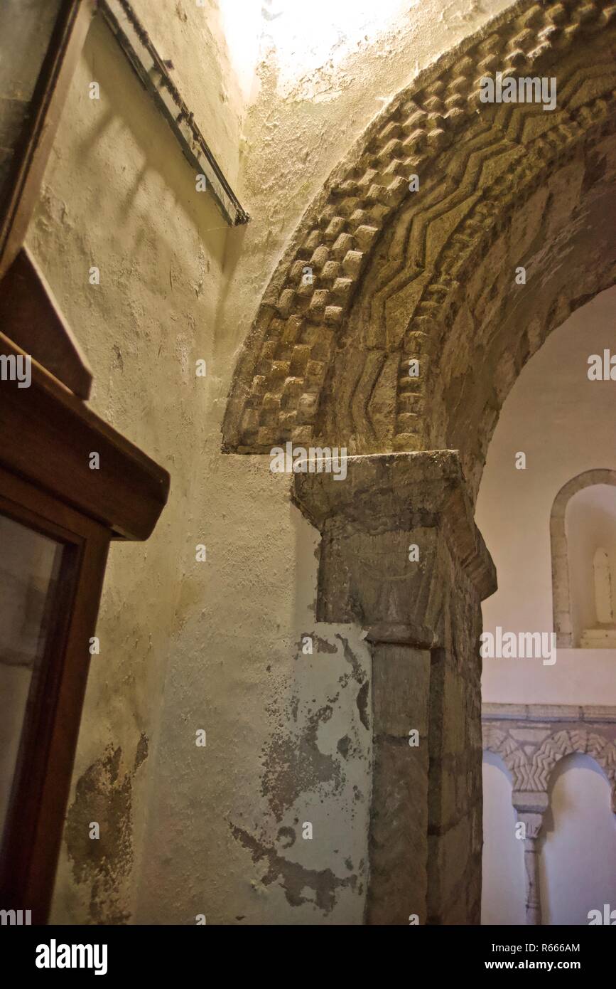 Carved detail on stone arch in interior view of Penmon Priory St ...