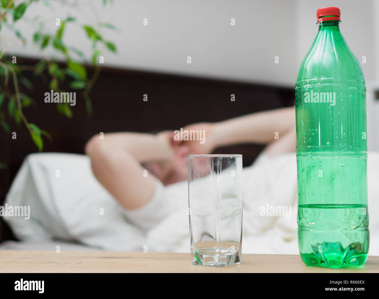 Man lying in bed and suffering from hangover Stock Photo - Alamy