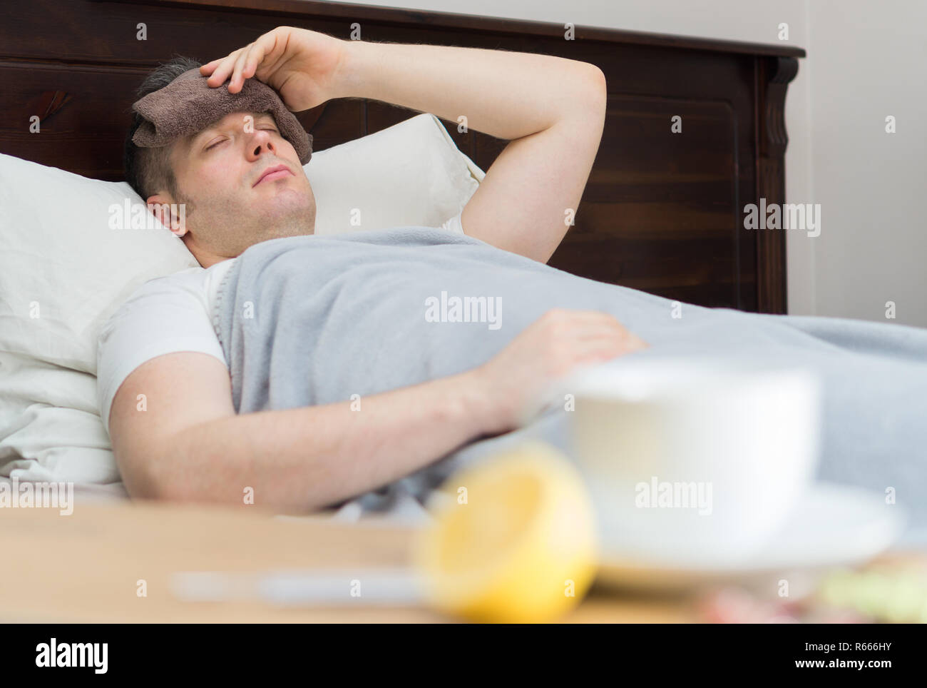 Sick man with fever lying in the bed Stock Photo - Alamy