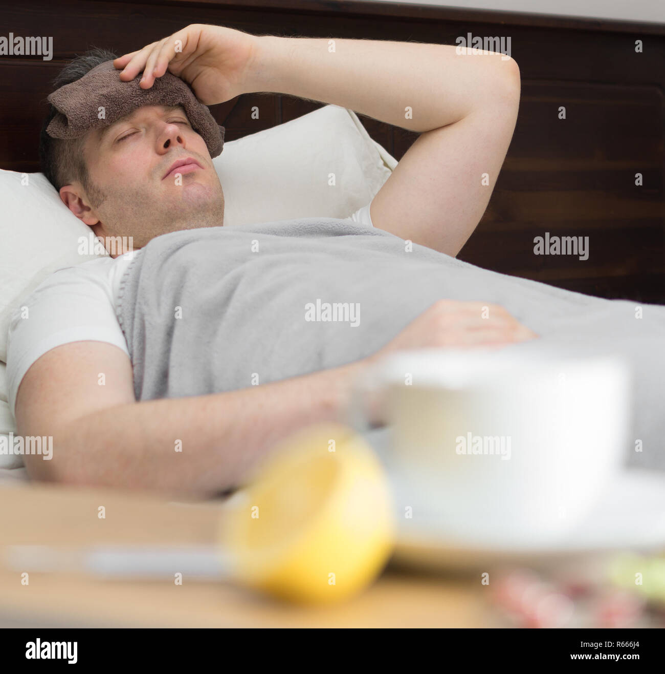 Sick man with fever lying in the bed Stock Photo - Alamy
