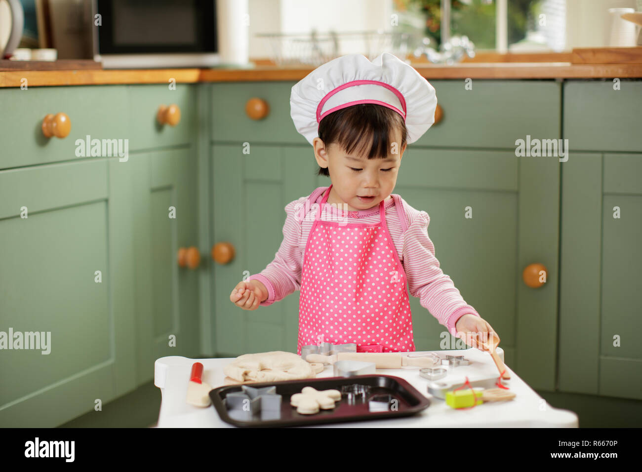 toddler baby girl pretend play baking bread Stock Photo - Alamy