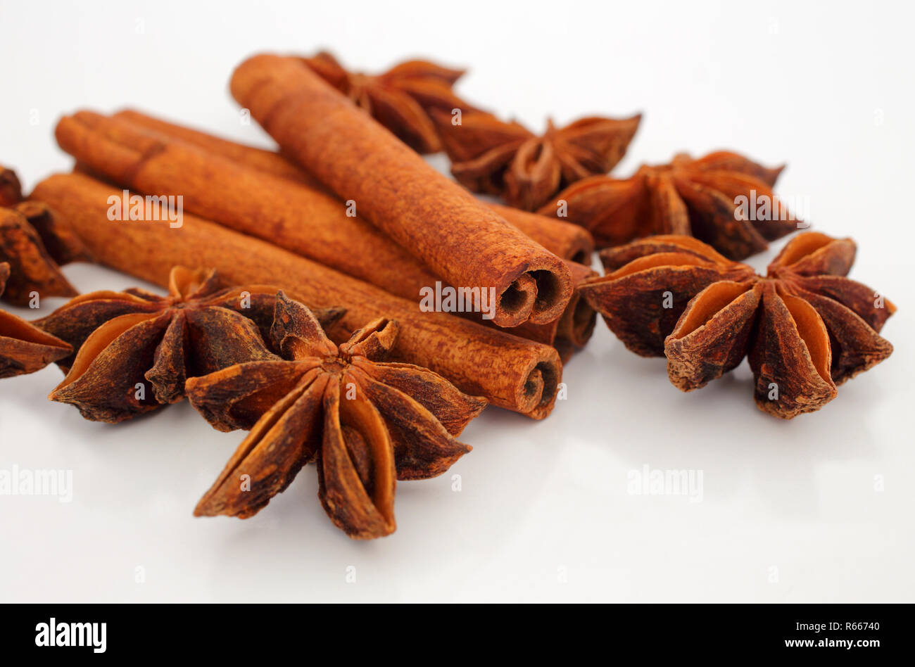 Cinnamon sticks and star aniseed on white reflective background ...