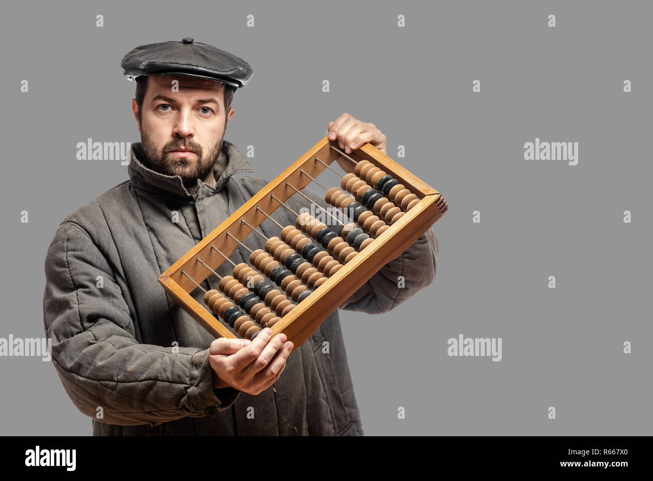 Old fashioned bearded man with wooden retro abacus, studio shot ...