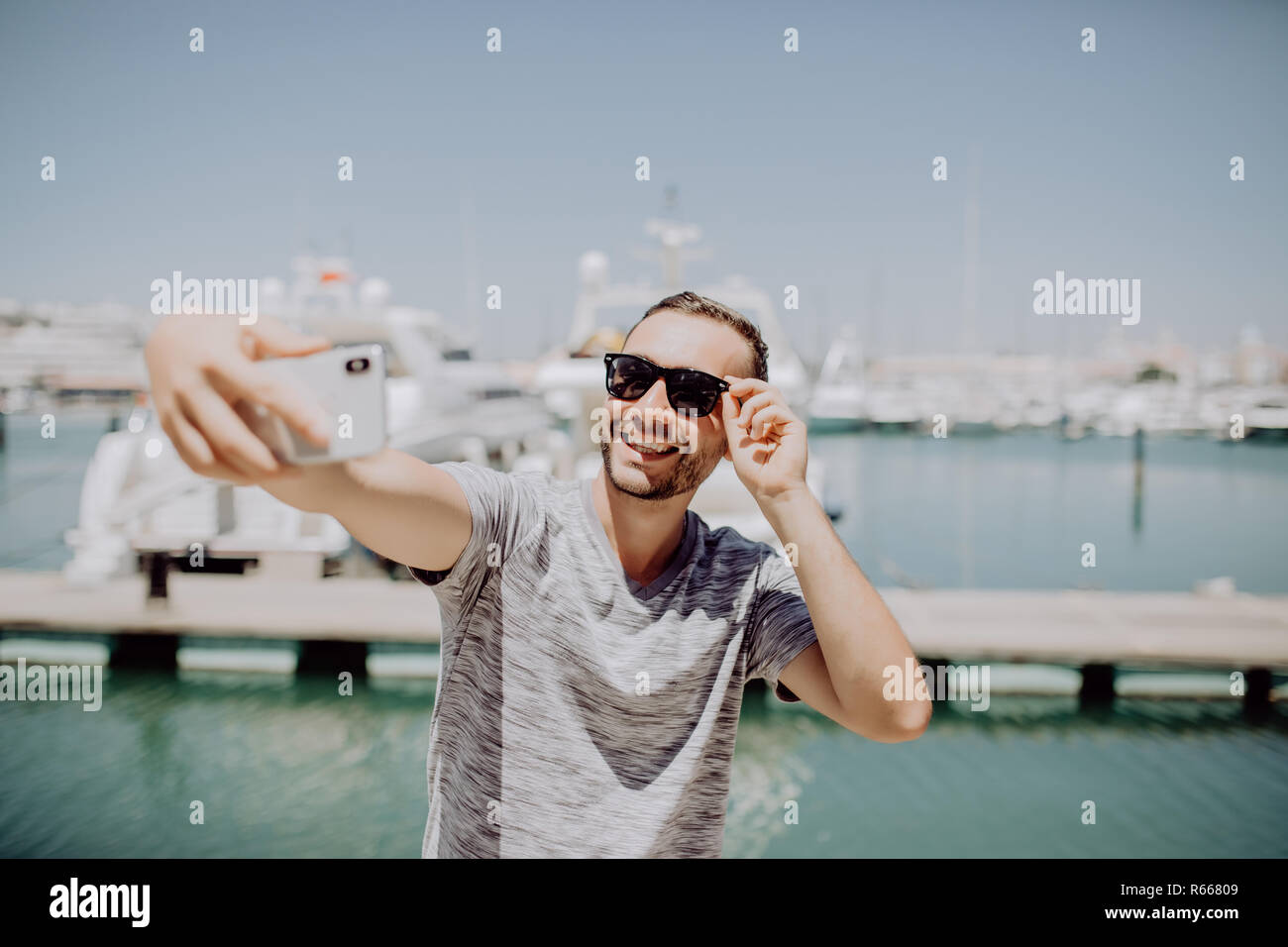 Young handsome man in sunglasses take selfie mobile phone for social ...