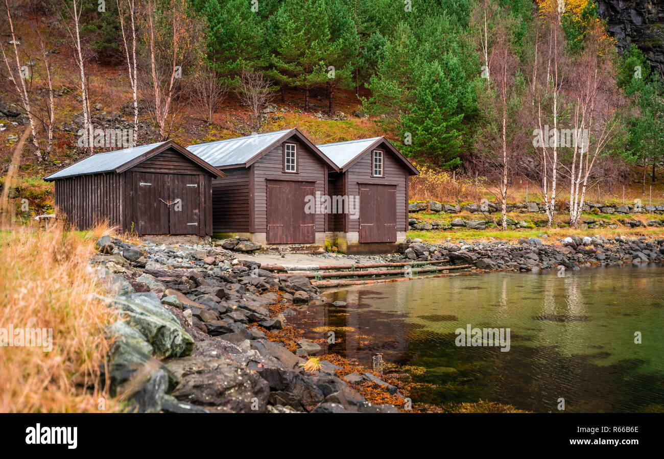 Three wooden huts on the shore of a fiord Stock Photo - Alamy