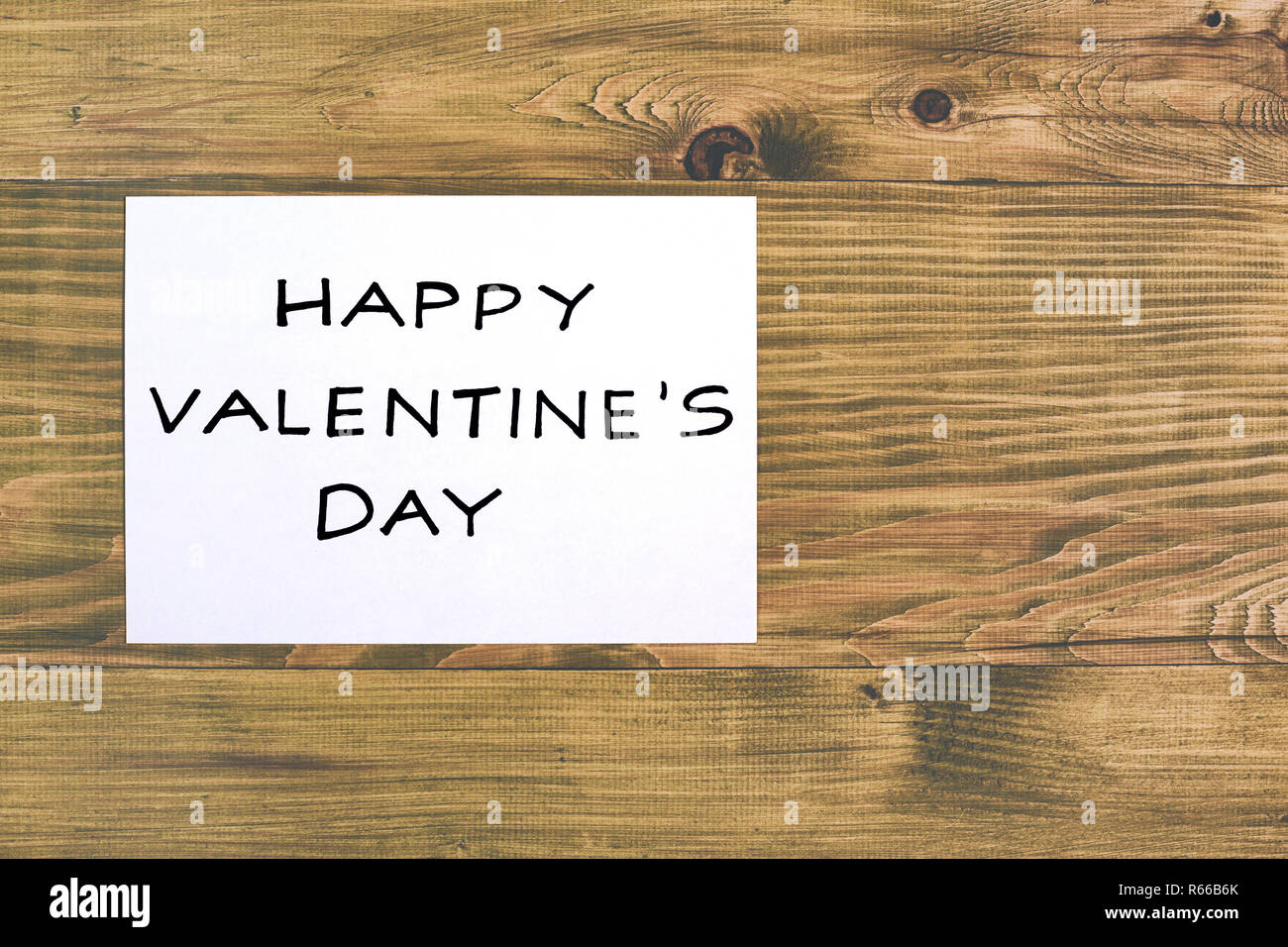 White paper with message for Valentine's day on wooden table Stock ...