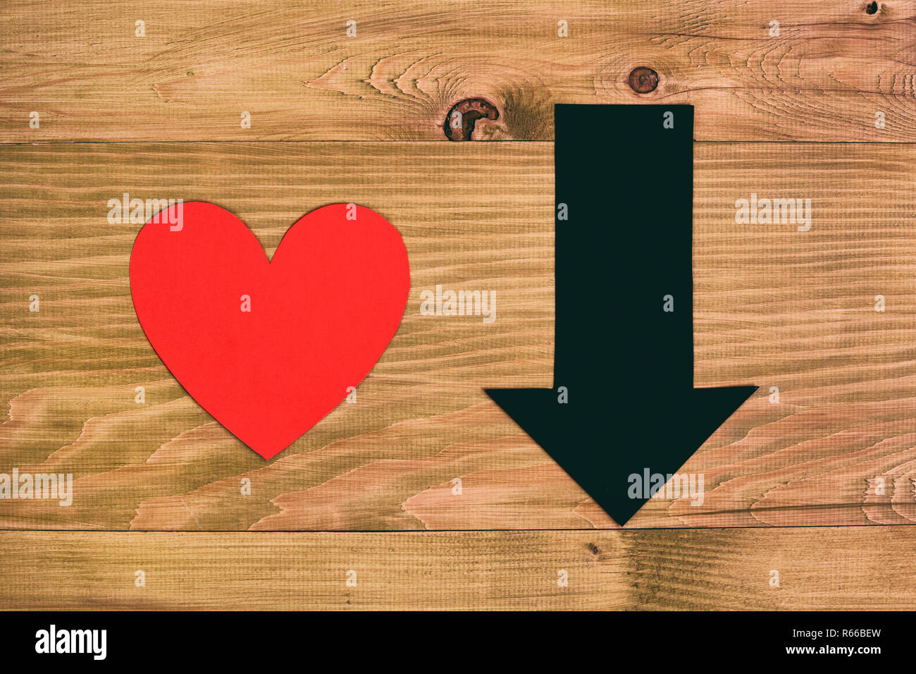 Red heart and arrow going down on wooden table,relationship breakup ...