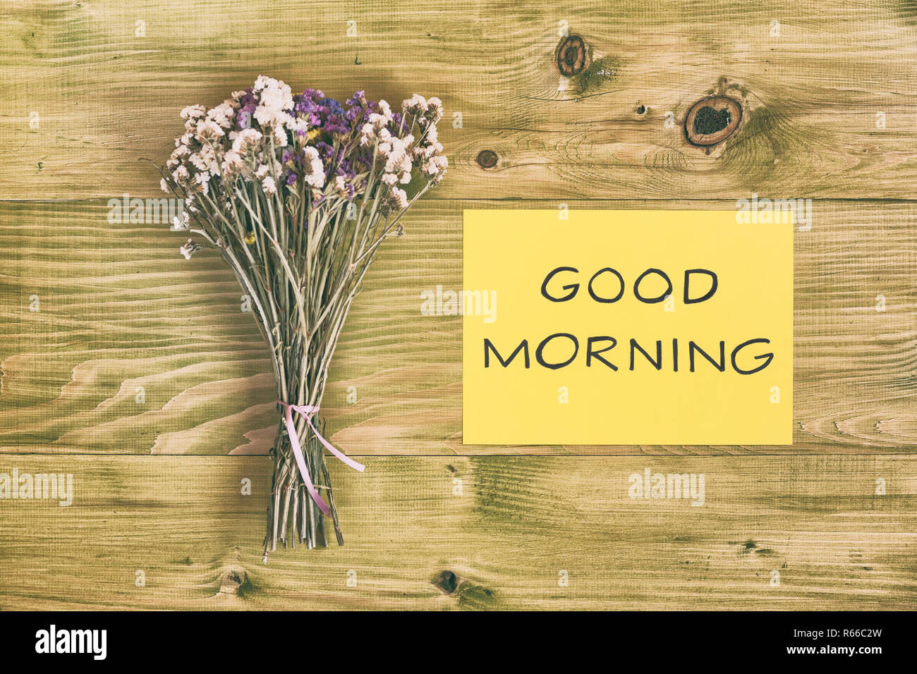 Beautiful bouquet of flowers and text good morning on wooden table ...