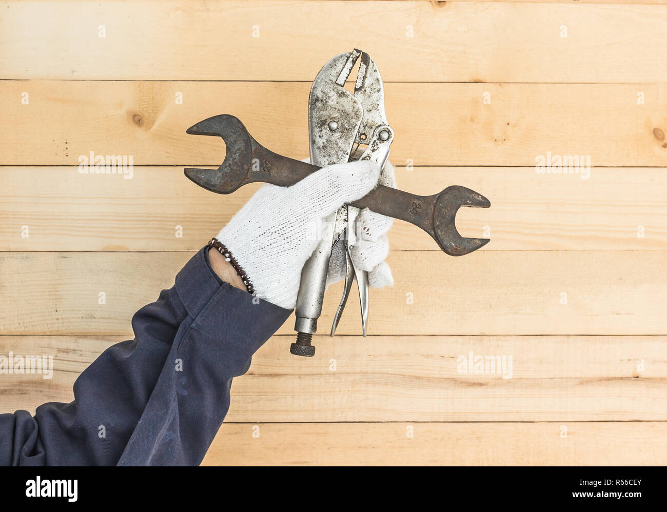 Hand in glove holding Spanner and Adjustable wrench Stock Photo - Alamy