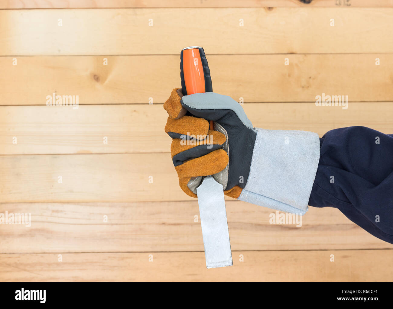 Hand in glove holding chisel Stock Photo - Alamy