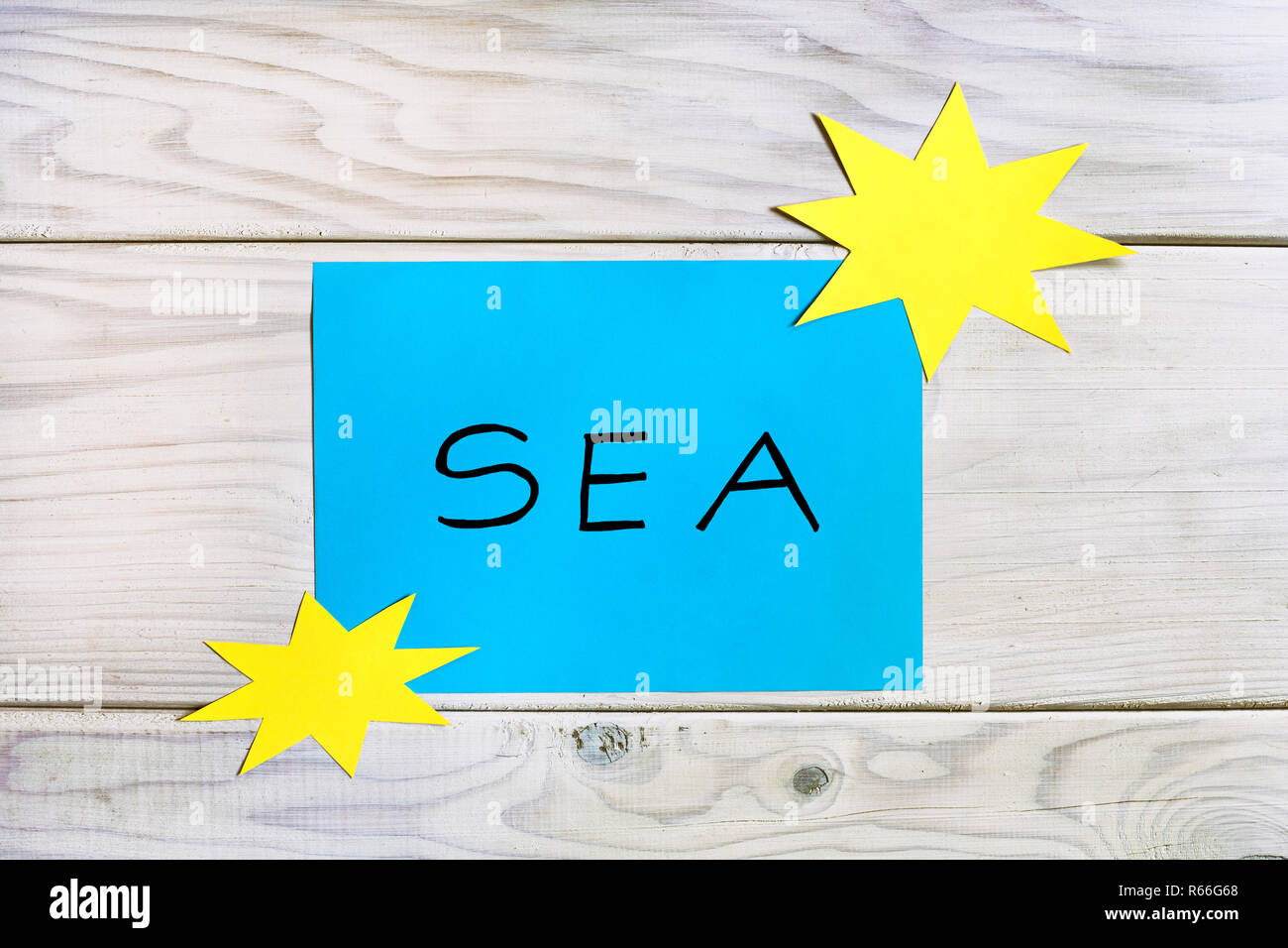Word sea with sun shapes on wooden table Stock Photo - Alamy