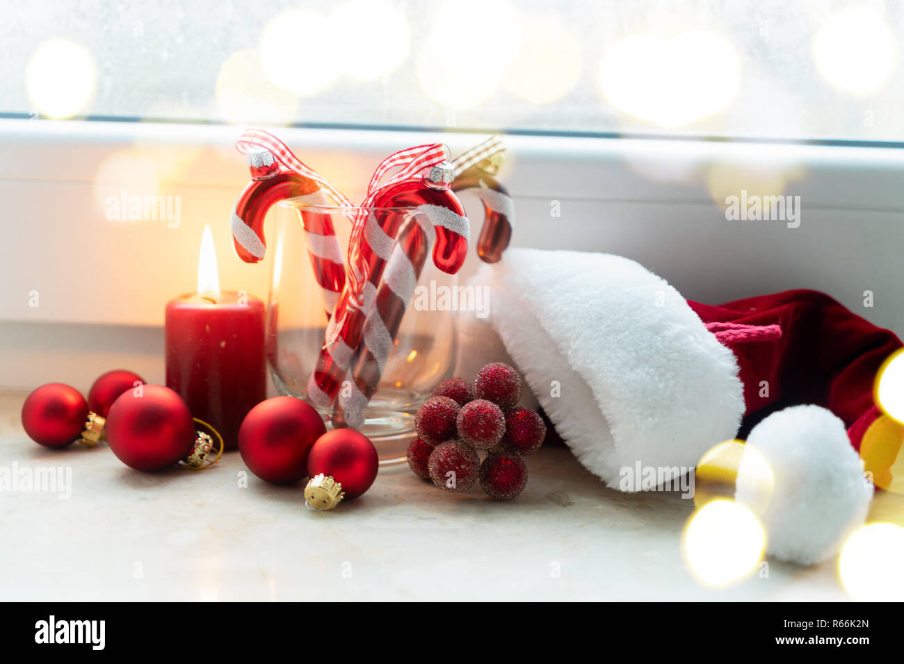 Christmas Scene With Burning Candle Sanra Claus Hat And Decorations On Winter Windowsill With