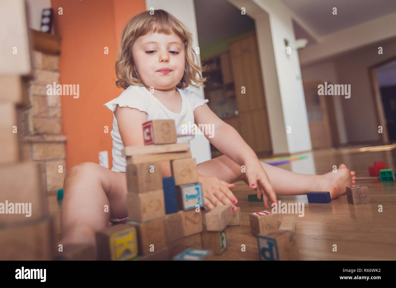 Girl playing with building blocks on floor Stock Photo - Alamy
