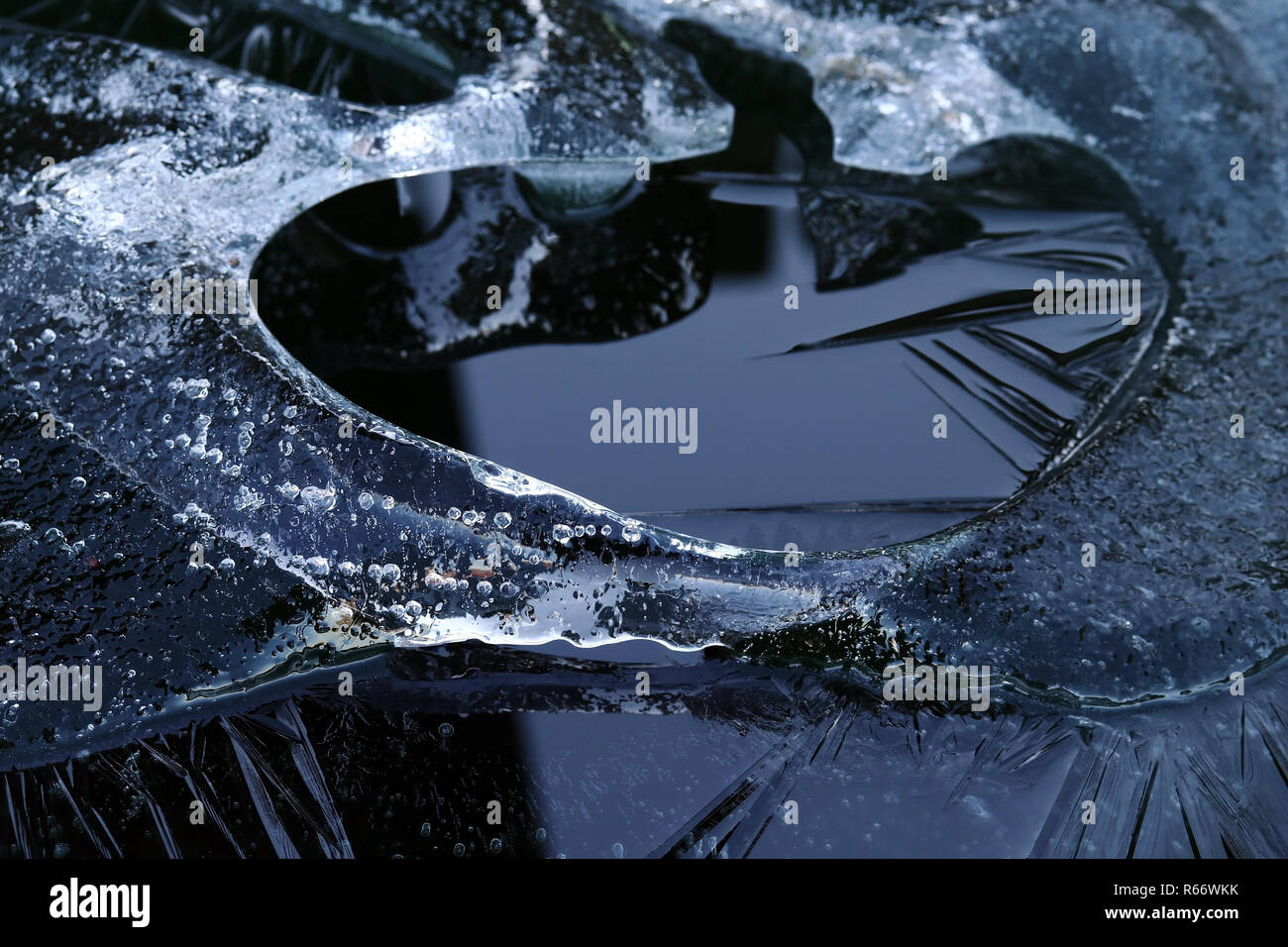 a chunk of ice with frozen bubbles in the water. a small iceberg in the ...
