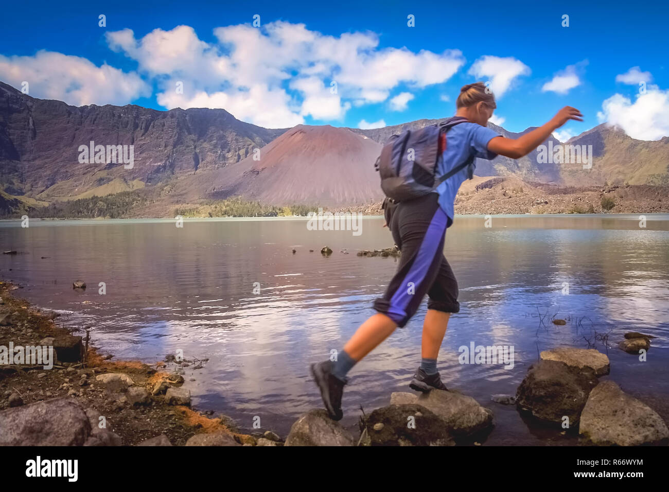 Girl jumping over stones on the lakeshore Stock Photo - Alamy