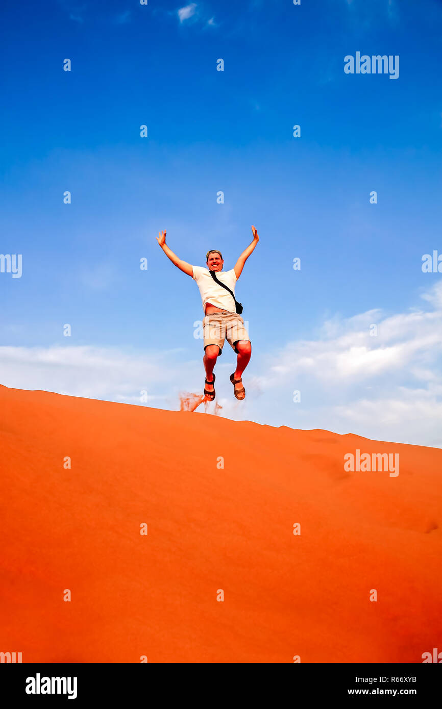 Tourist jumping over the sand dunes in Merzouga Stock Photo - Alamy