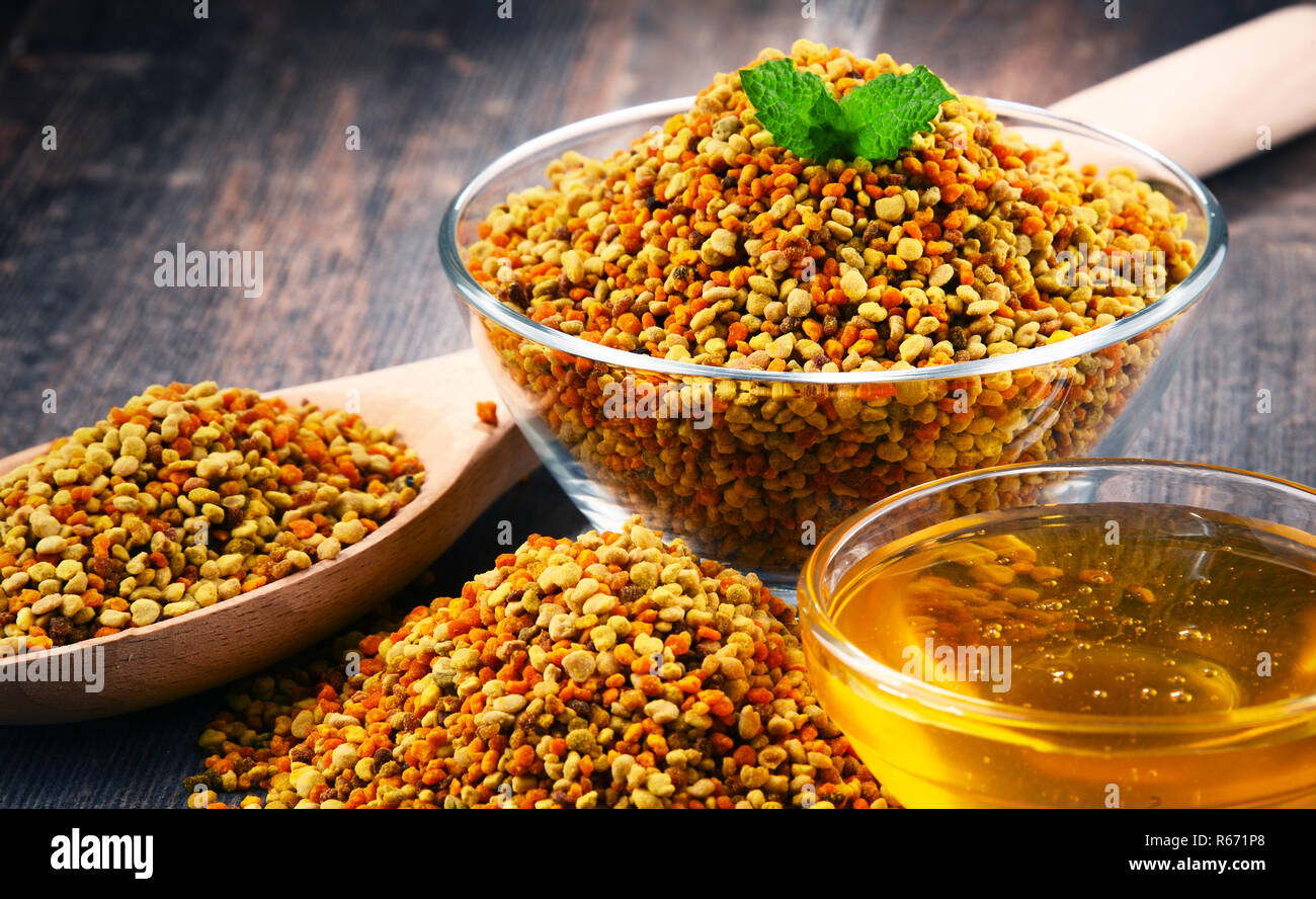 Bowls with bee pollen and honey on kitchen table Stock Photo - Alamy
