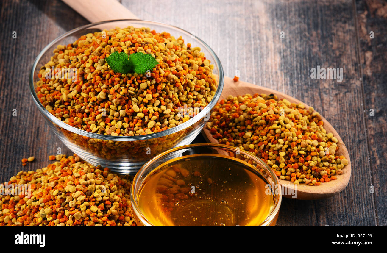 Bowls with bee pollen and honey on kitchen table Stock Photo - Alamy