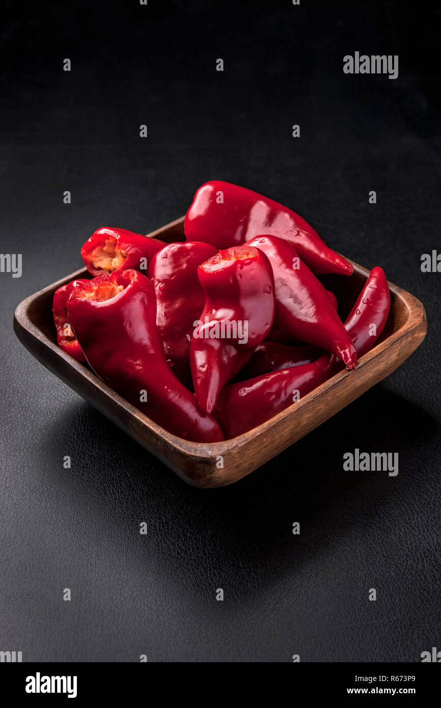 A close up of a wooden bowl full of bright red chili peppers Stock ...