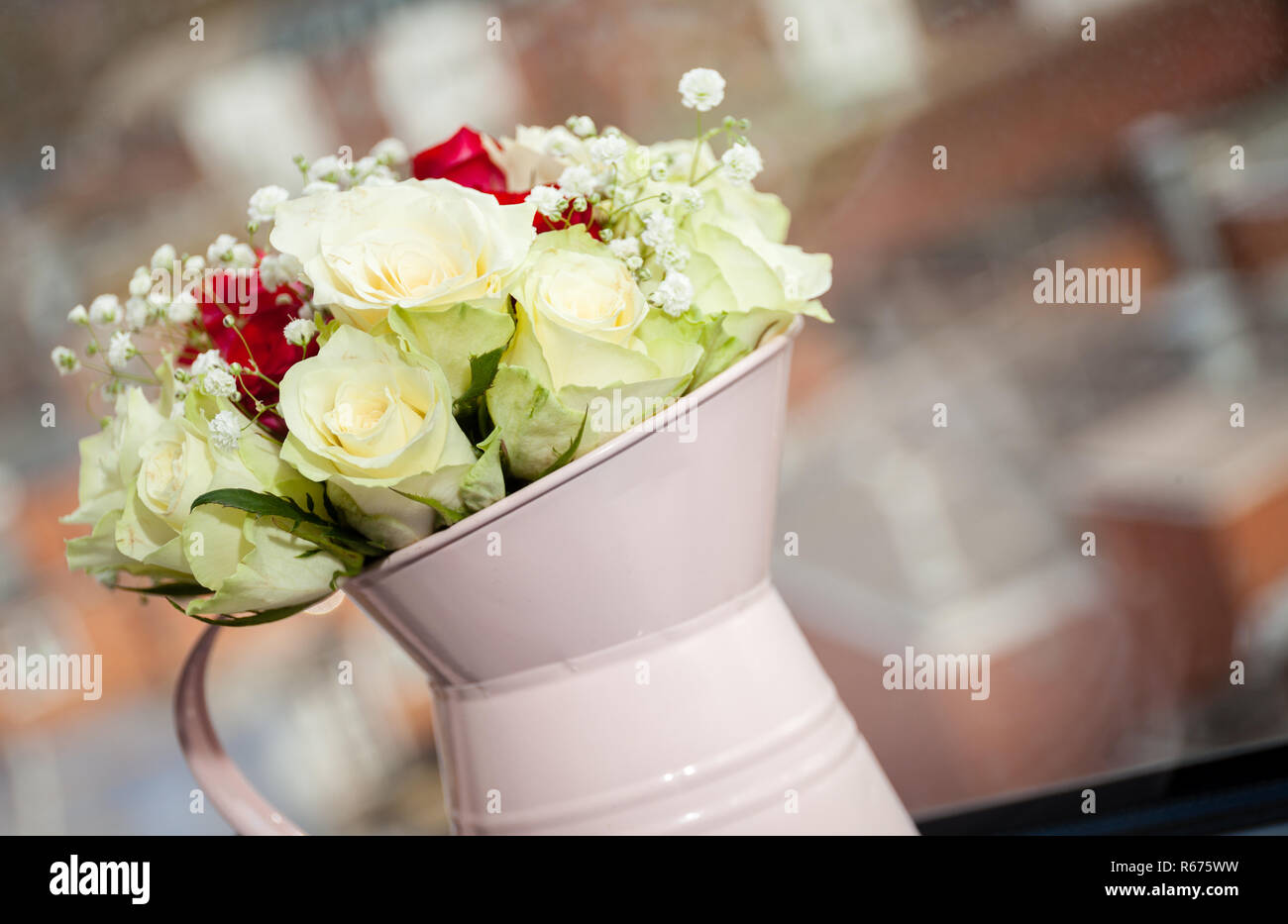 Watering can with roses bouquet Stock Photo - Alamy