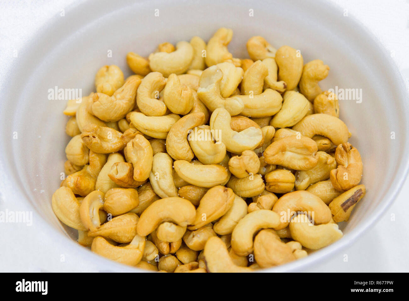 Cashews In a white container Stock Photo - Alamy