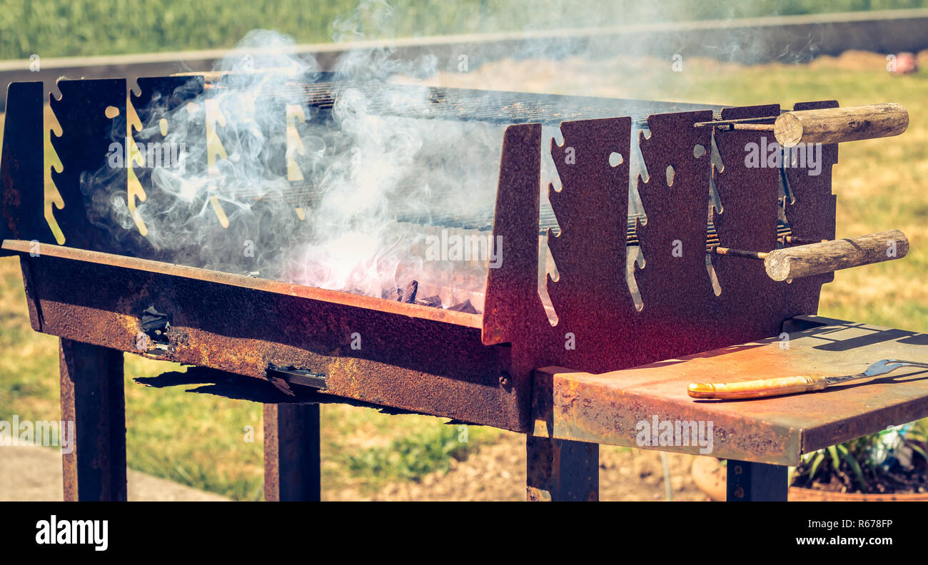 an old rusty steaming barbecue when lighting in garden Stock Photo - Alamy