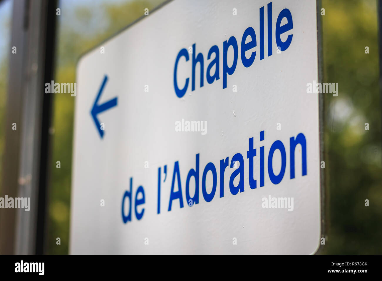 in Lourdes, France, a white sign indicates the direction of the chapel ...