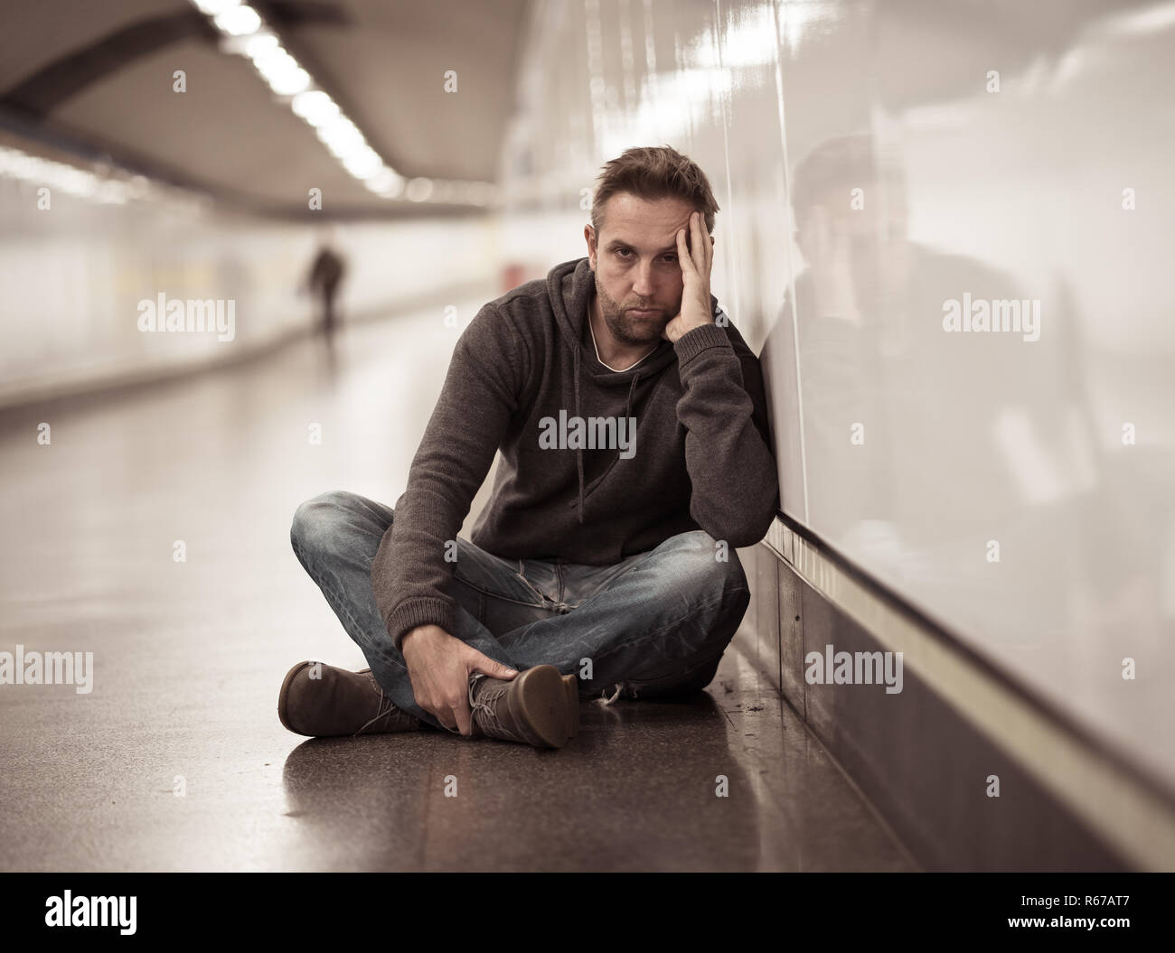 Sad young man crying suffering depression stress sitting on ground ...