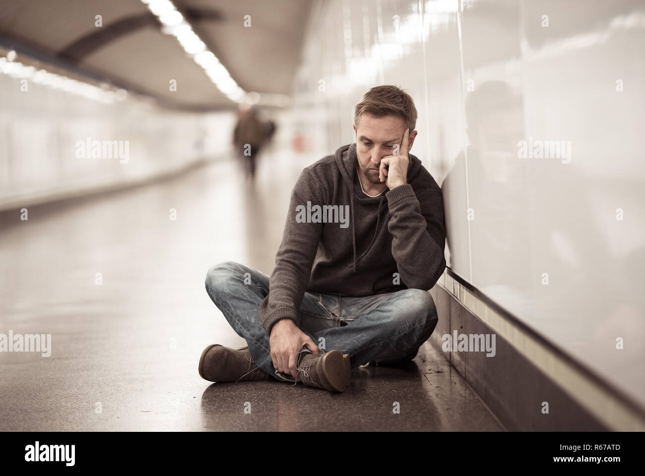 Sad young man crying suffering depression stress sitting on ground ...