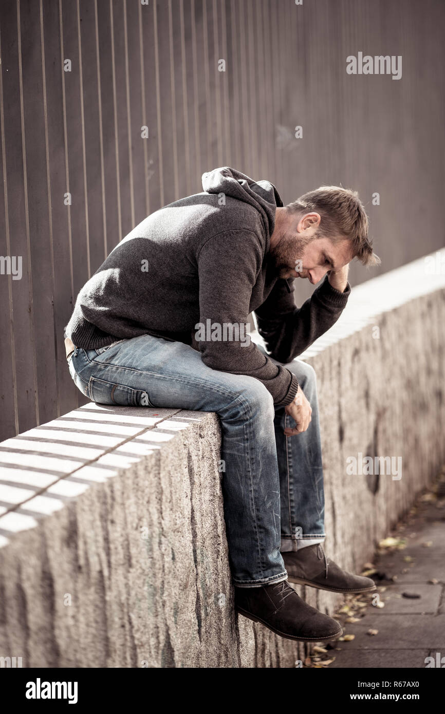 Young attractive man suffering from depression stress sitting alone and ...