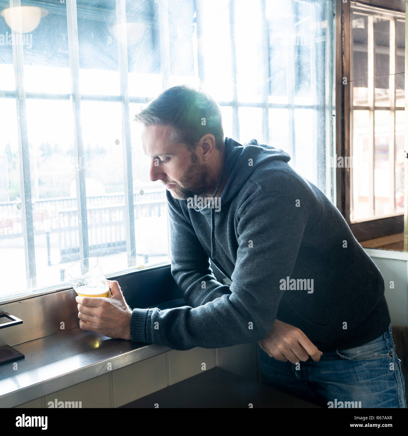 Portrait of a attractive caucasian man drinking beer in a bar pub ...