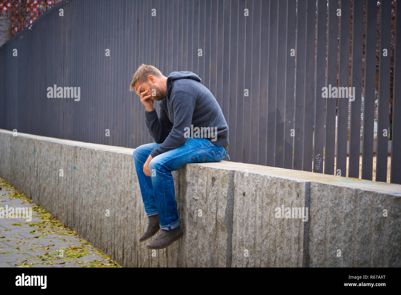 Young attractive man suffering from depression stress sitting alone and ...