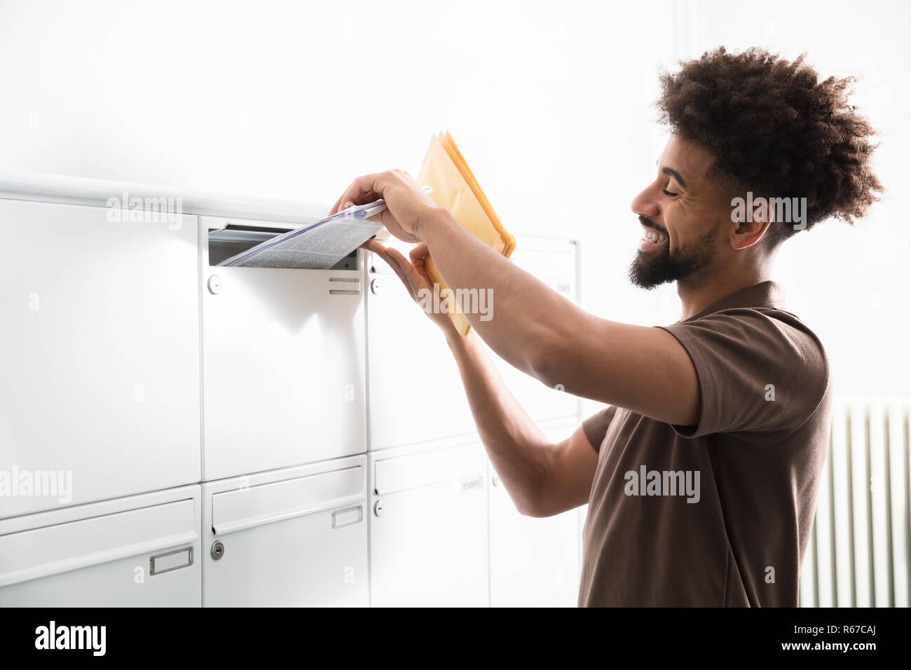Man Putting Letters In Mailbox Stock Photo - Alamy