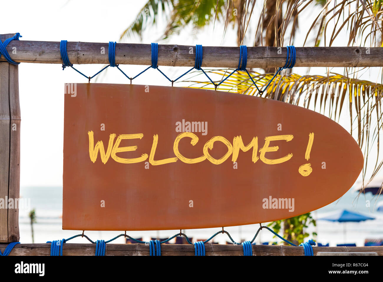 Orange vintage signboard in shape of surfboard with Welcome text and ...