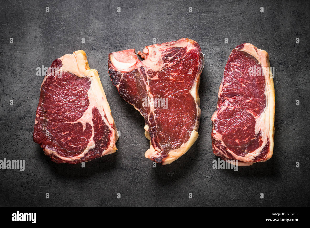 Dry aged beef steaks - ribeye, striploin, t-bone steaks on Black Stock ...