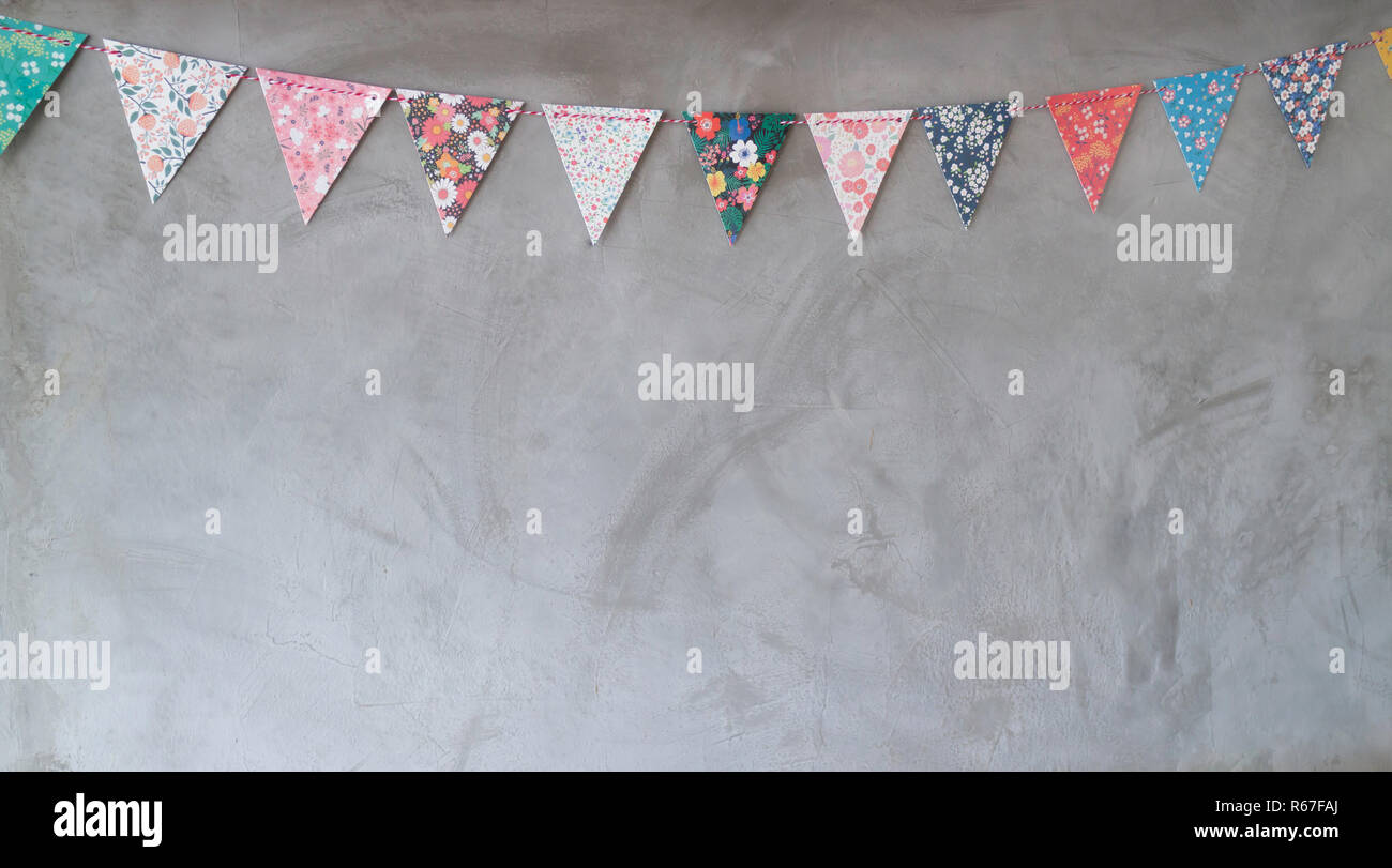 Triangle papers hanging on the grey wall decoration in house Stock ...