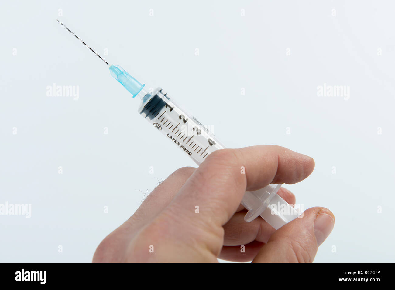 a syringe in his hand Stock Photo - Alamy