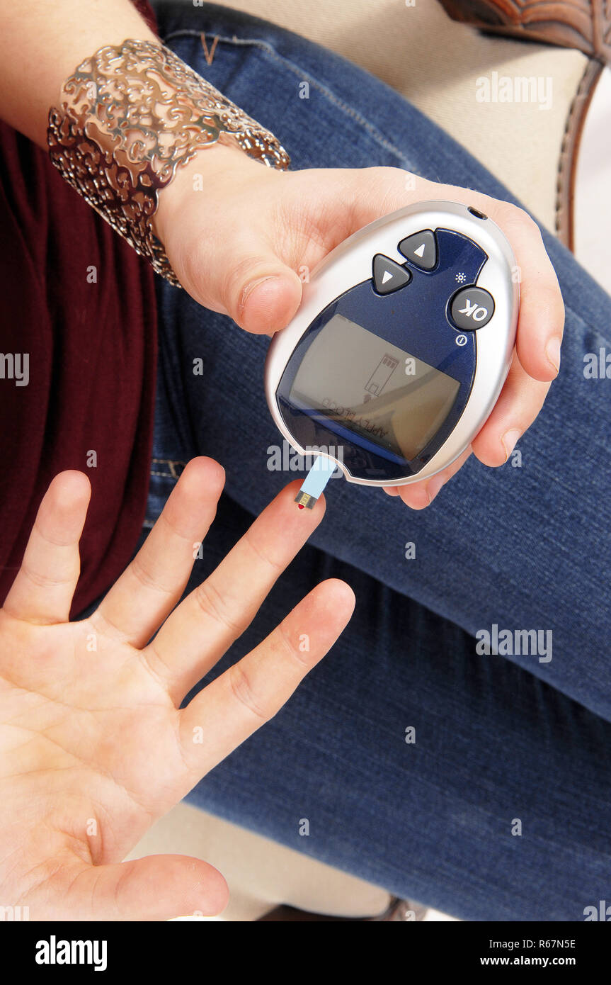 Woman testing her blood sugar Stock Photo - Alamy