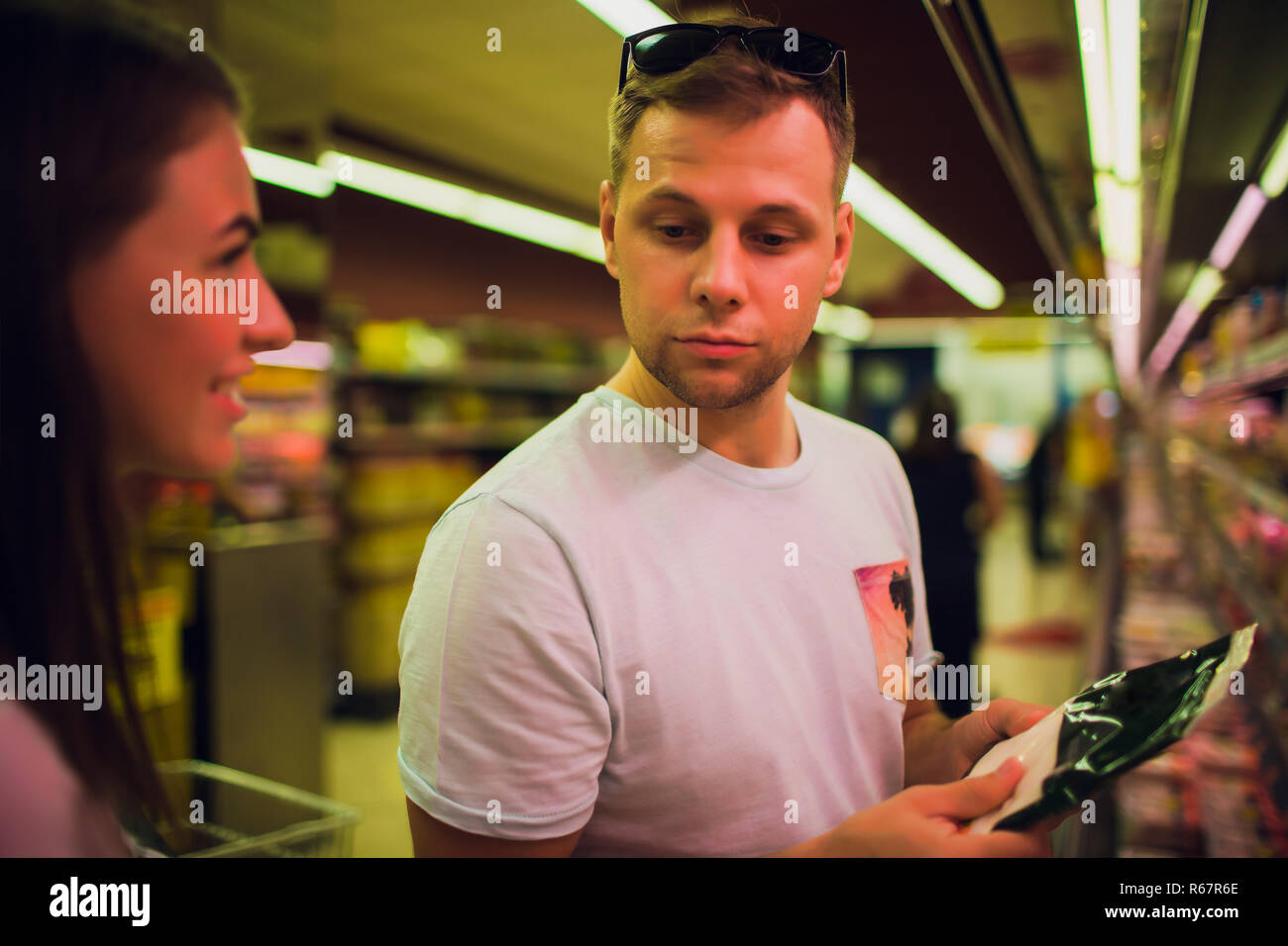Portrait man customer who is standing with purchases in supermarket ...