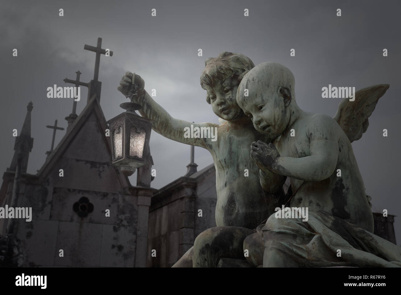 Child angels statue of an old european cemetery with a lamp in the hand ...