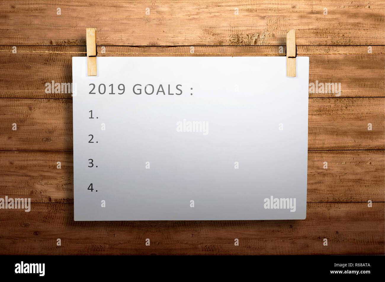 White paper with 2019 goals list hanged on the rope over wooden ...