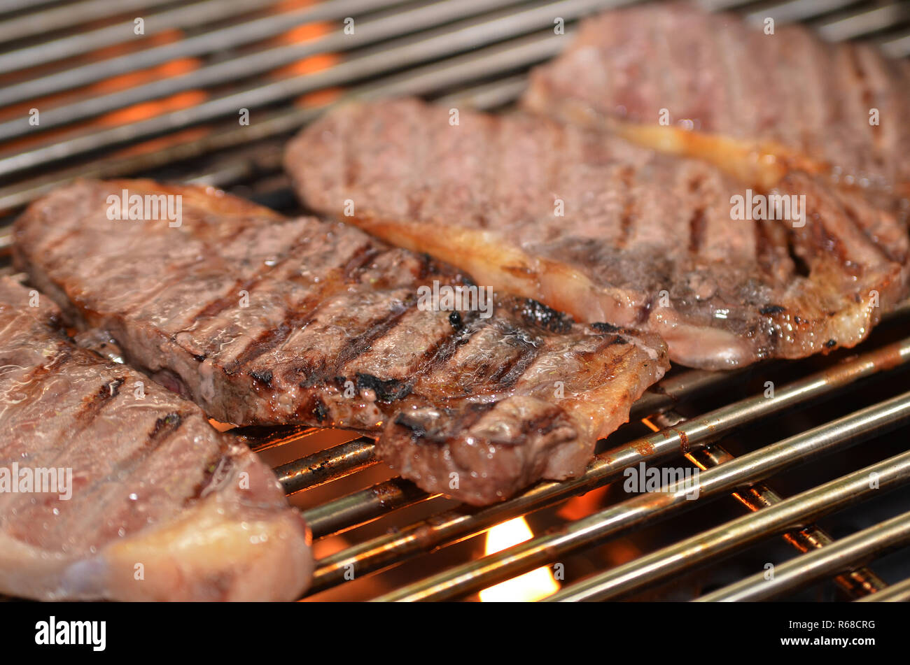 Beef steaks on the grill Stock Photo - Alamy