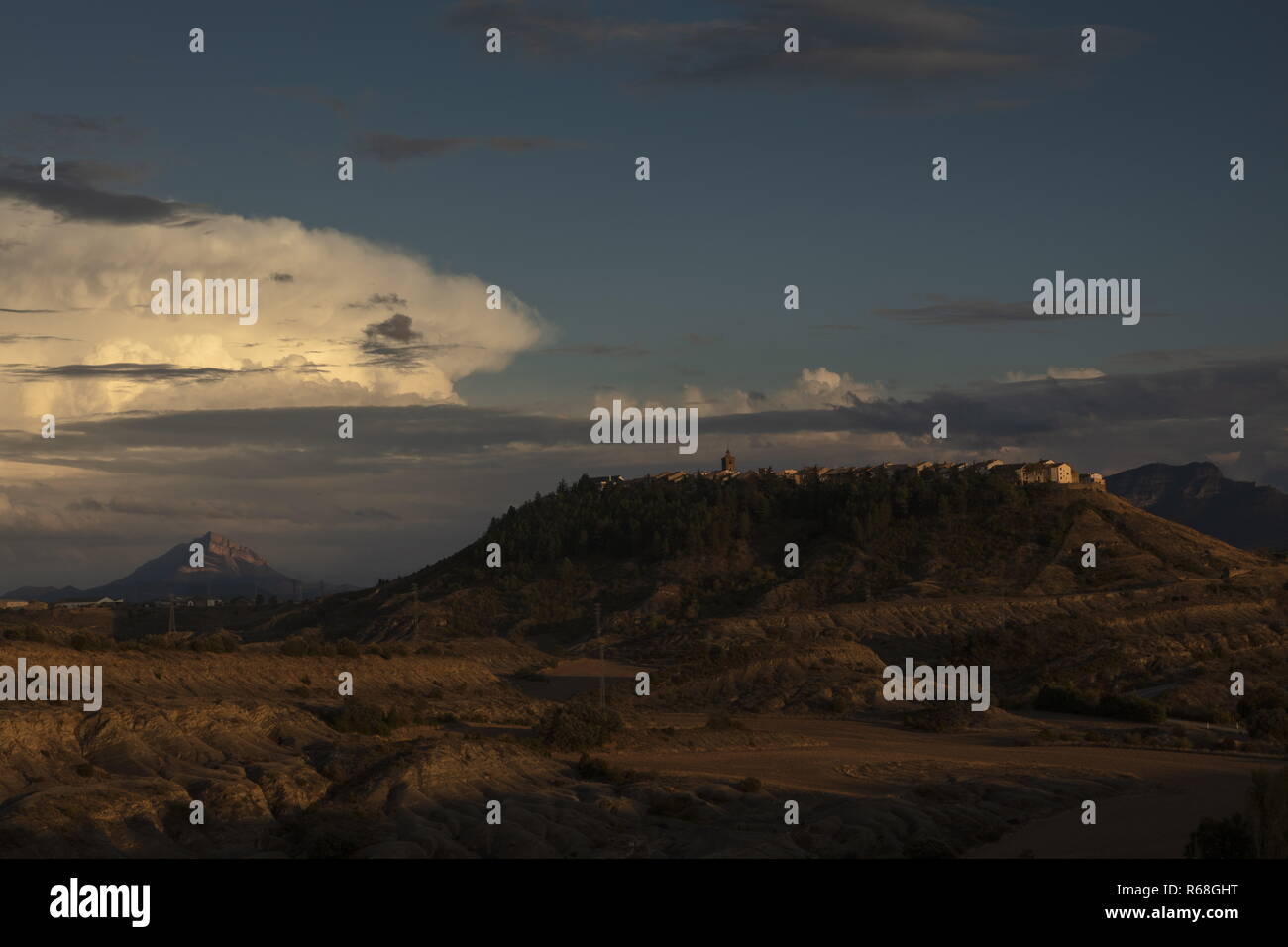 Berdun hilltop village in the evening, set among eroded badlands, in ...