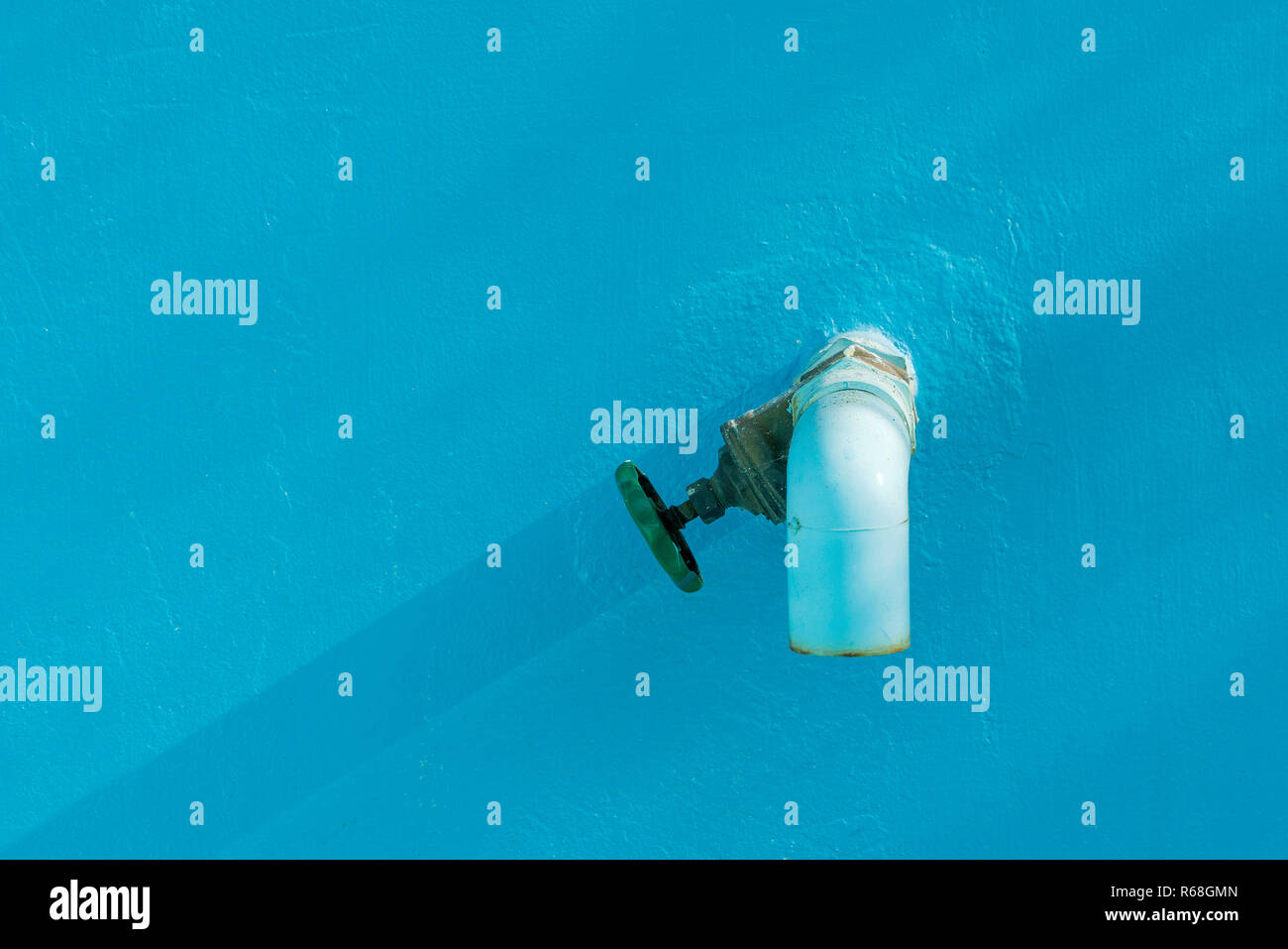 Blue water hose with water valve and blue background Stock Photo - Alamy