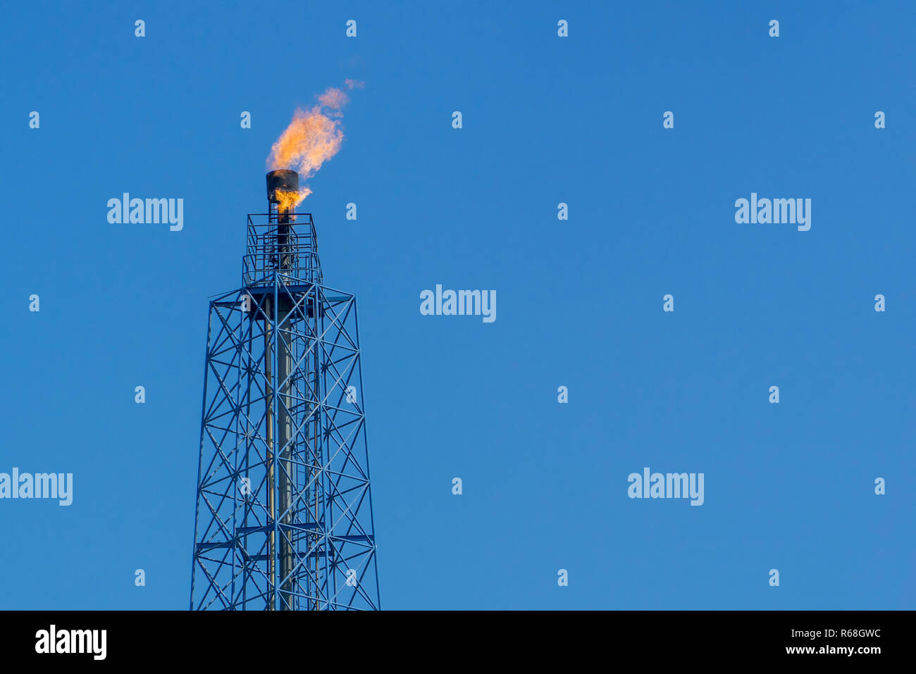Gas flares in petroleum refinery with blue sky background Stock Photo ...