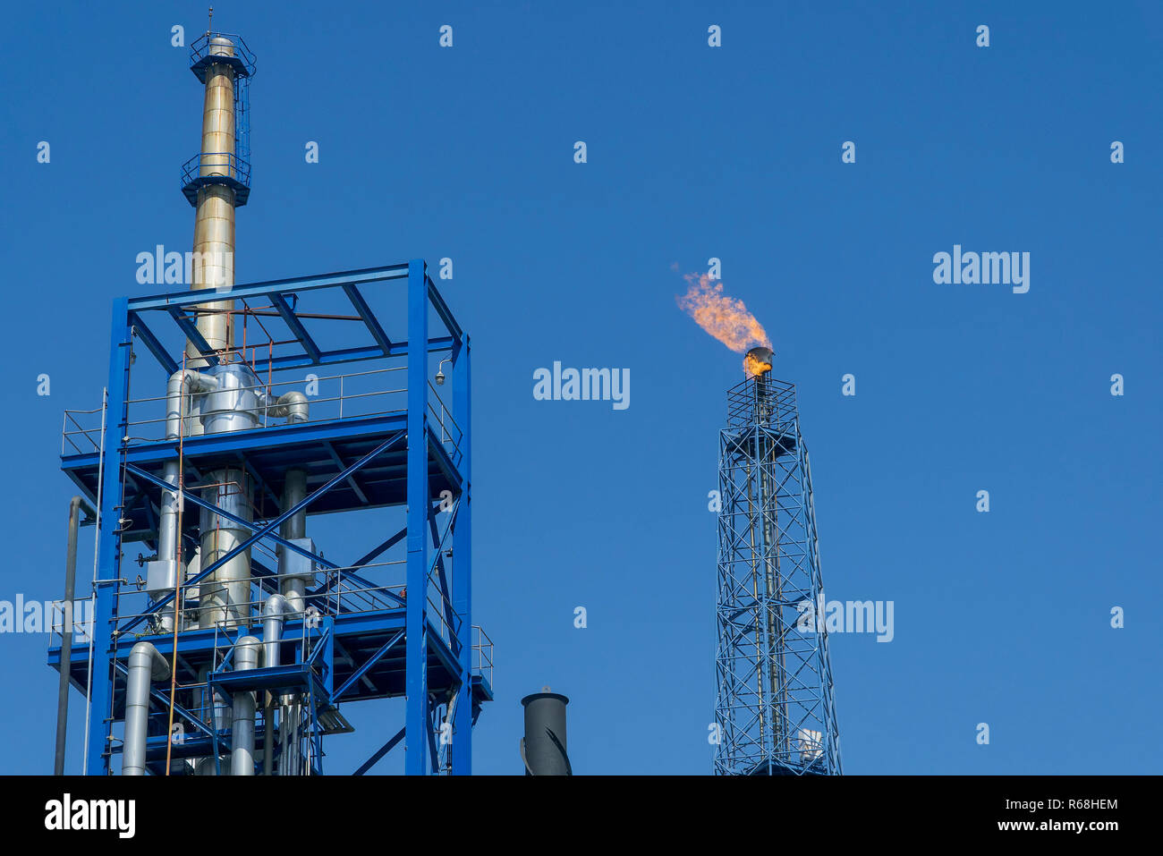 Gas flares in petroleum refinery with blue sky background Stock Photo ...