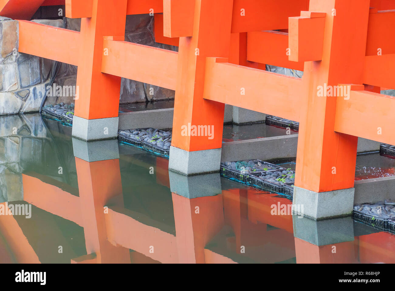 Columns of the red bridge with brook Stock Photo - Alamy